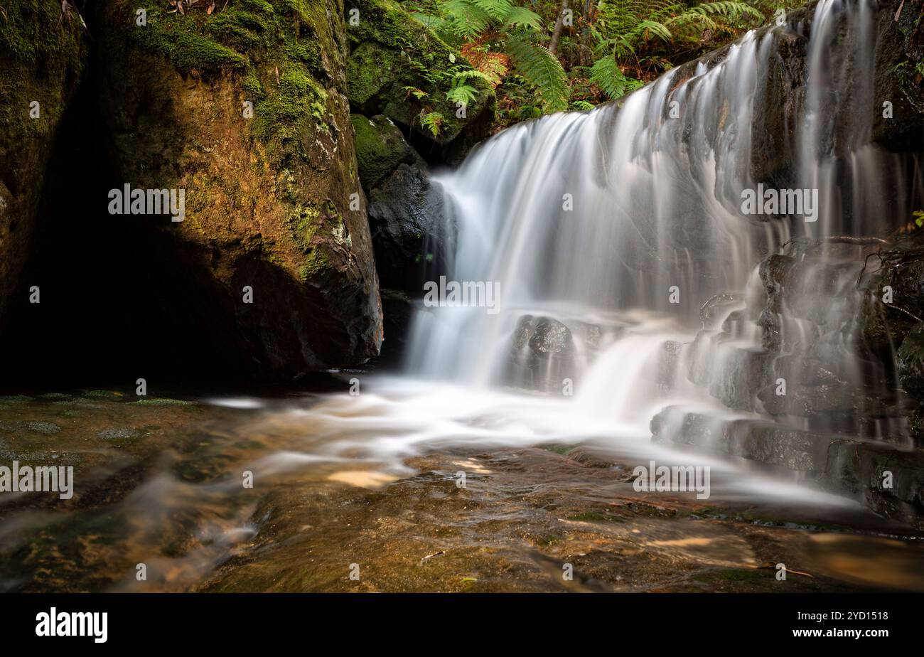 Waterfall in lush mountain gully Stock Photo - Alamy