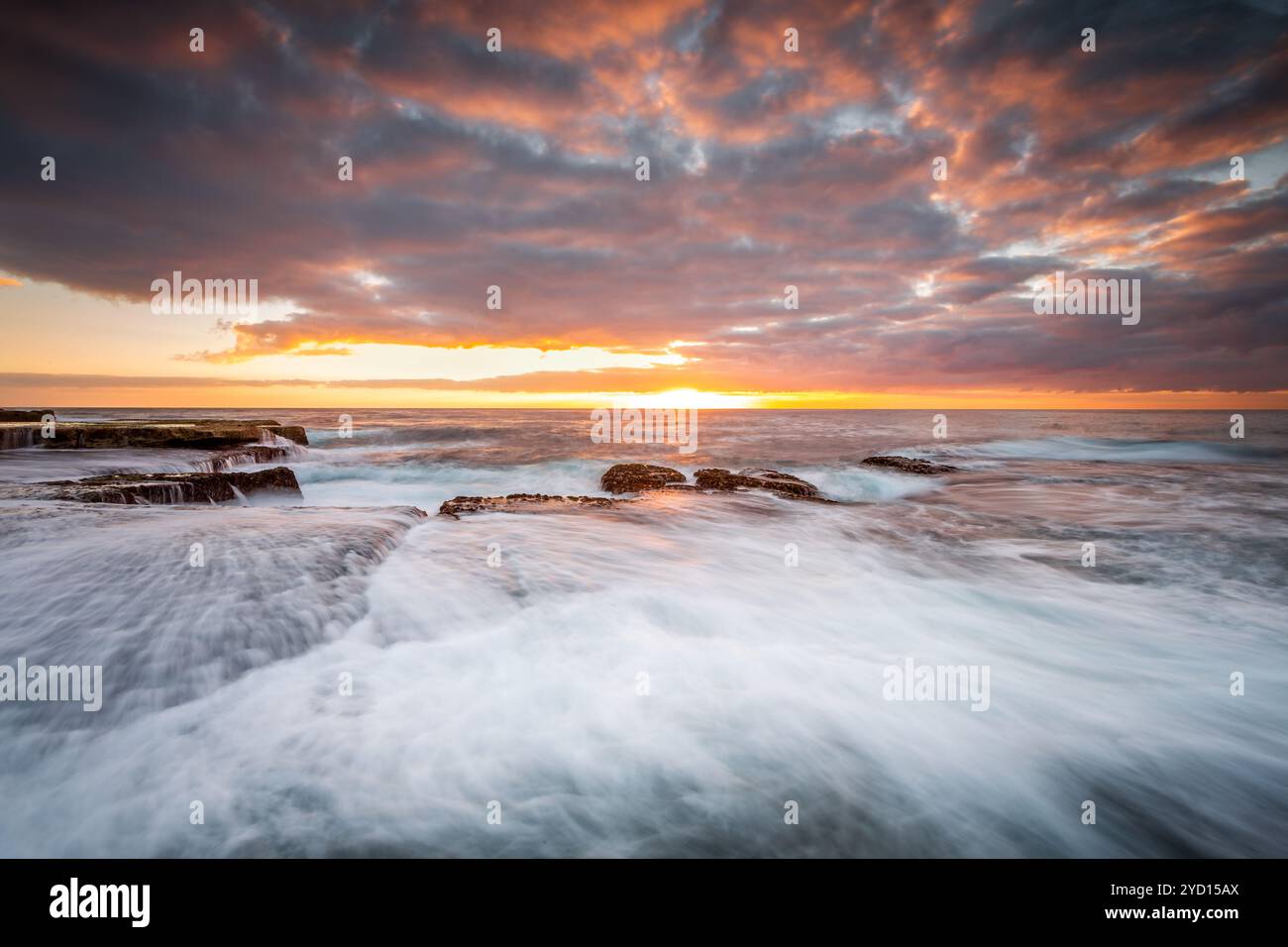 Tidal waves wash up onto the rocks and flow back to the ocean as ...