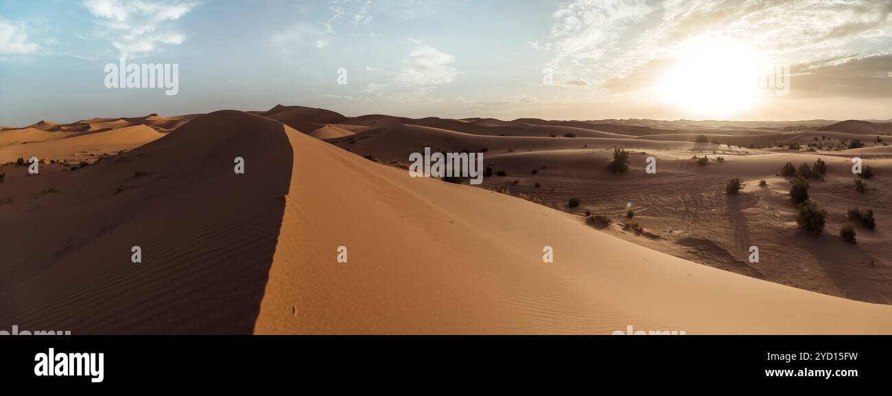 As the sun sets over the Sahara Desert in Morocco, soft shadows form on ...