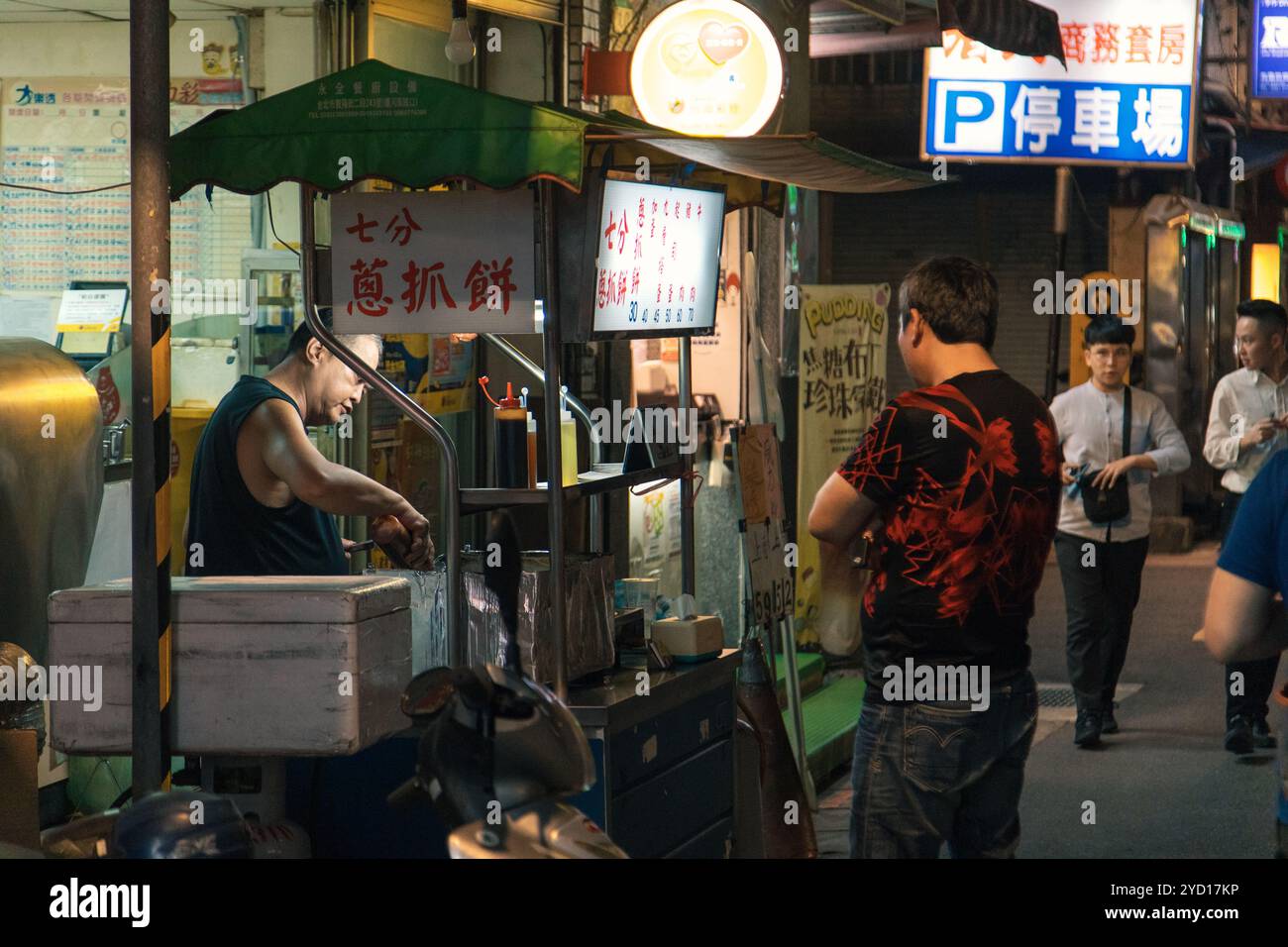 Taipei, Taiwan - October 10th 2019: Exploring vibrant street food culture in Taipei’s bustling ...