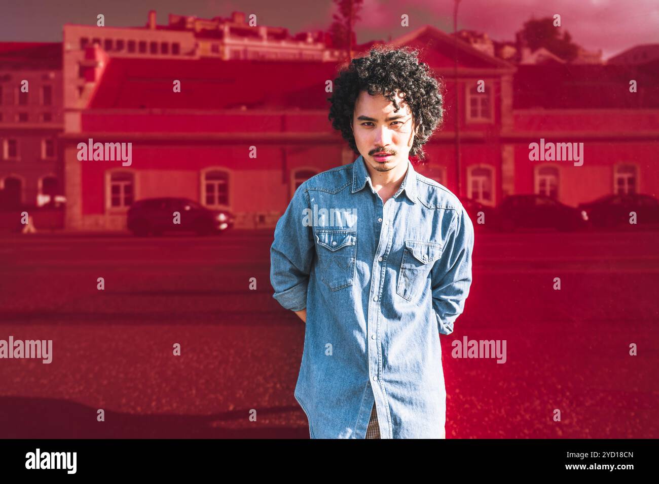 Portrait of a young Filipino male model with curly hair, wearing a ...