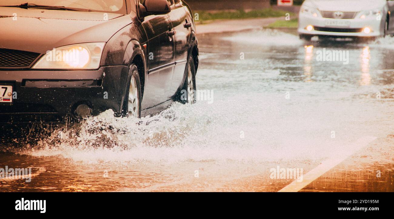 The car goes through a puddle. Puddles on the road. Water from the ...