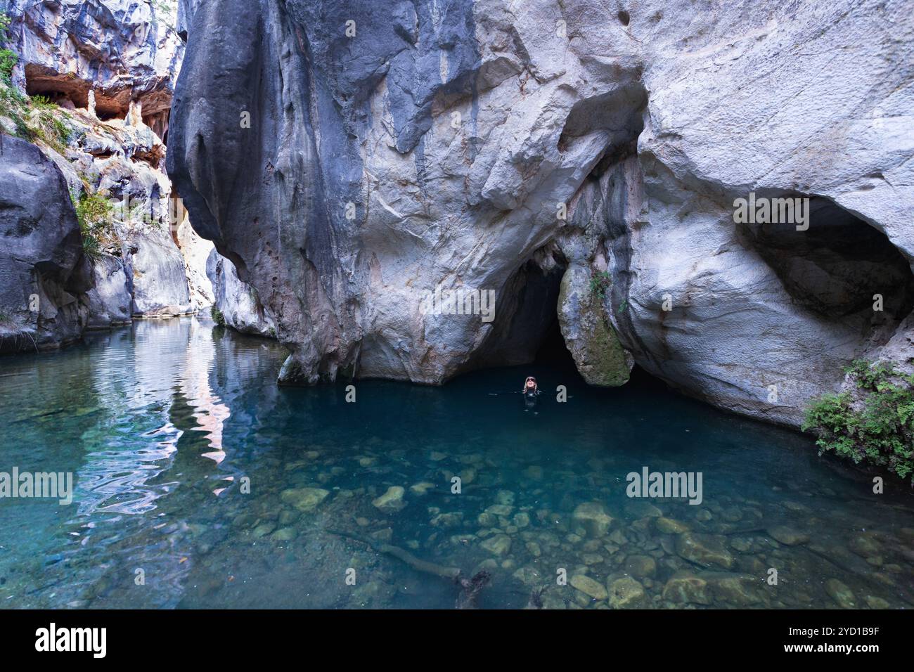 Adventurous female emerges from a water-filled cave opening in the ...