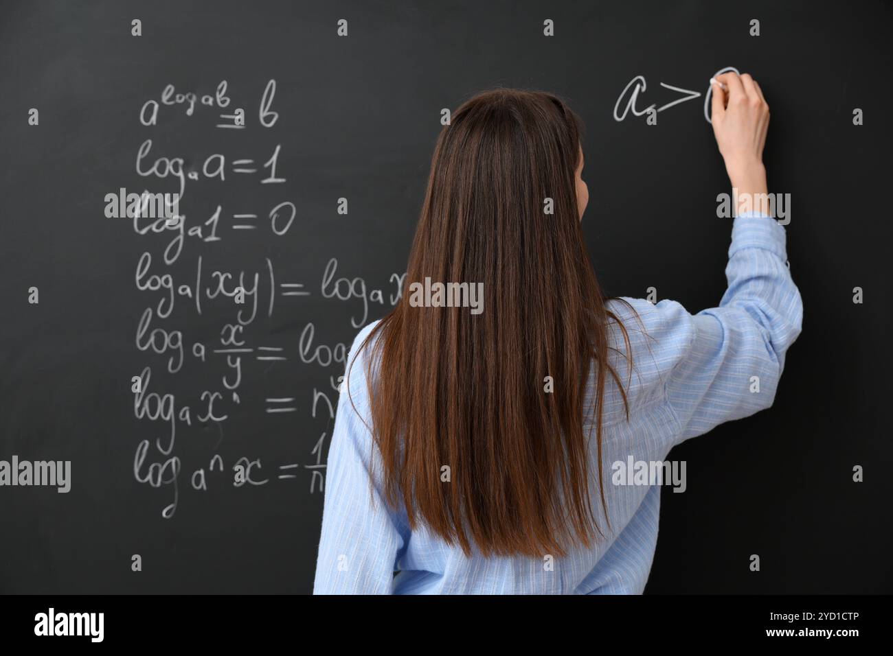 Young female math teacher in classroom, back view Stock Photo - Alamy