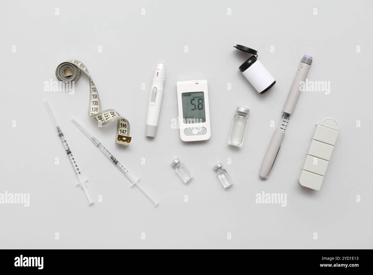 Glucometer with lancet pens, insulin and tape measure on light ...