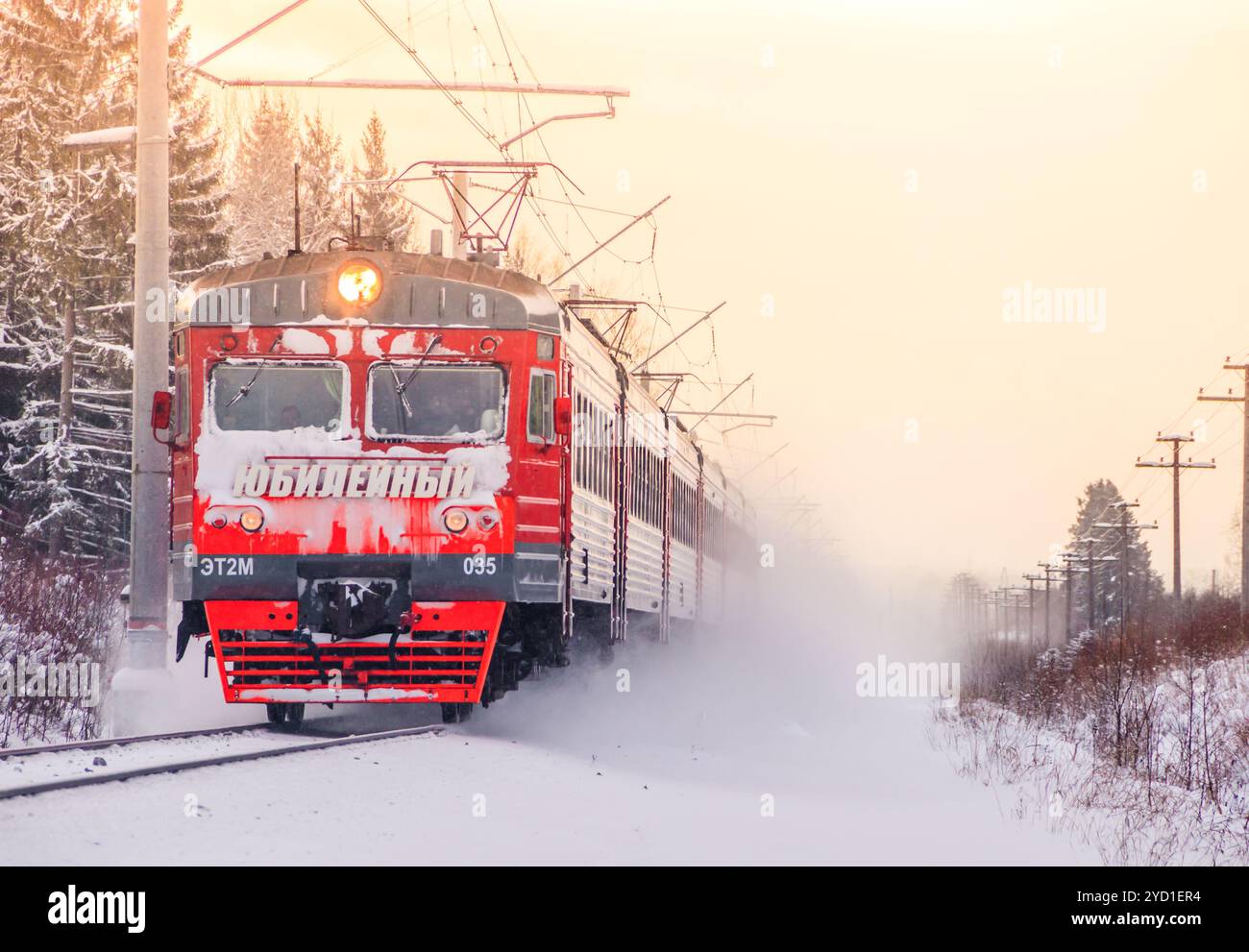 Russian train in the winter. The train rides by rail in the winter in ...