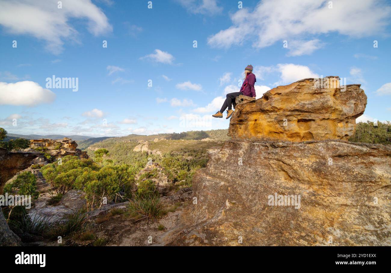 A bushwalker takes a break and admires splendid views in a landscape of pagodas, valleys ...