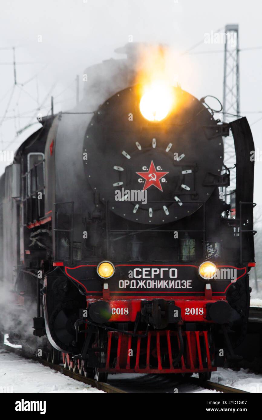 Old locomotive rides by rail in winter. Public transport. Passenger ...