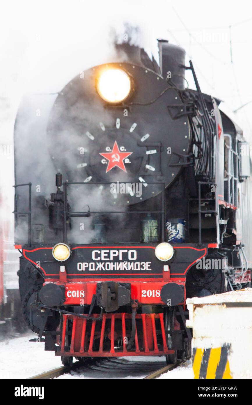 Old locomotive rides by rail in winter. Public transport. Passenger ...