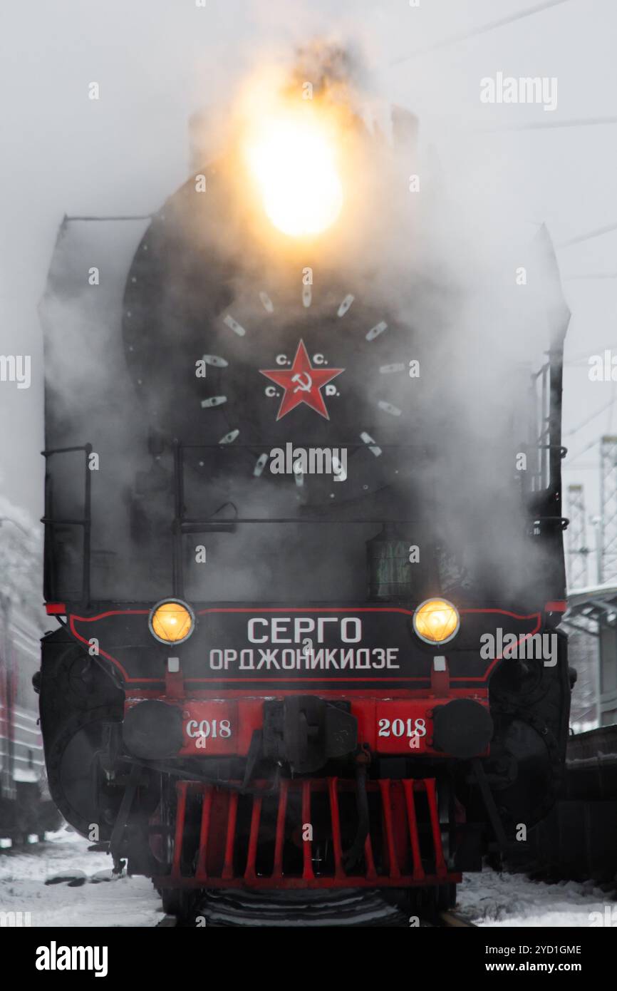 Old locomotive rides by rail in winter. Public transport. Passenger ...