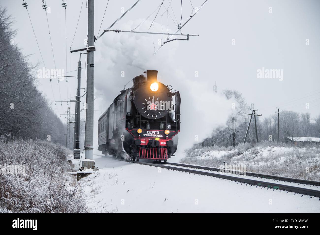 Old locomotive rides by rail in winter. Public transport. Passenger ...