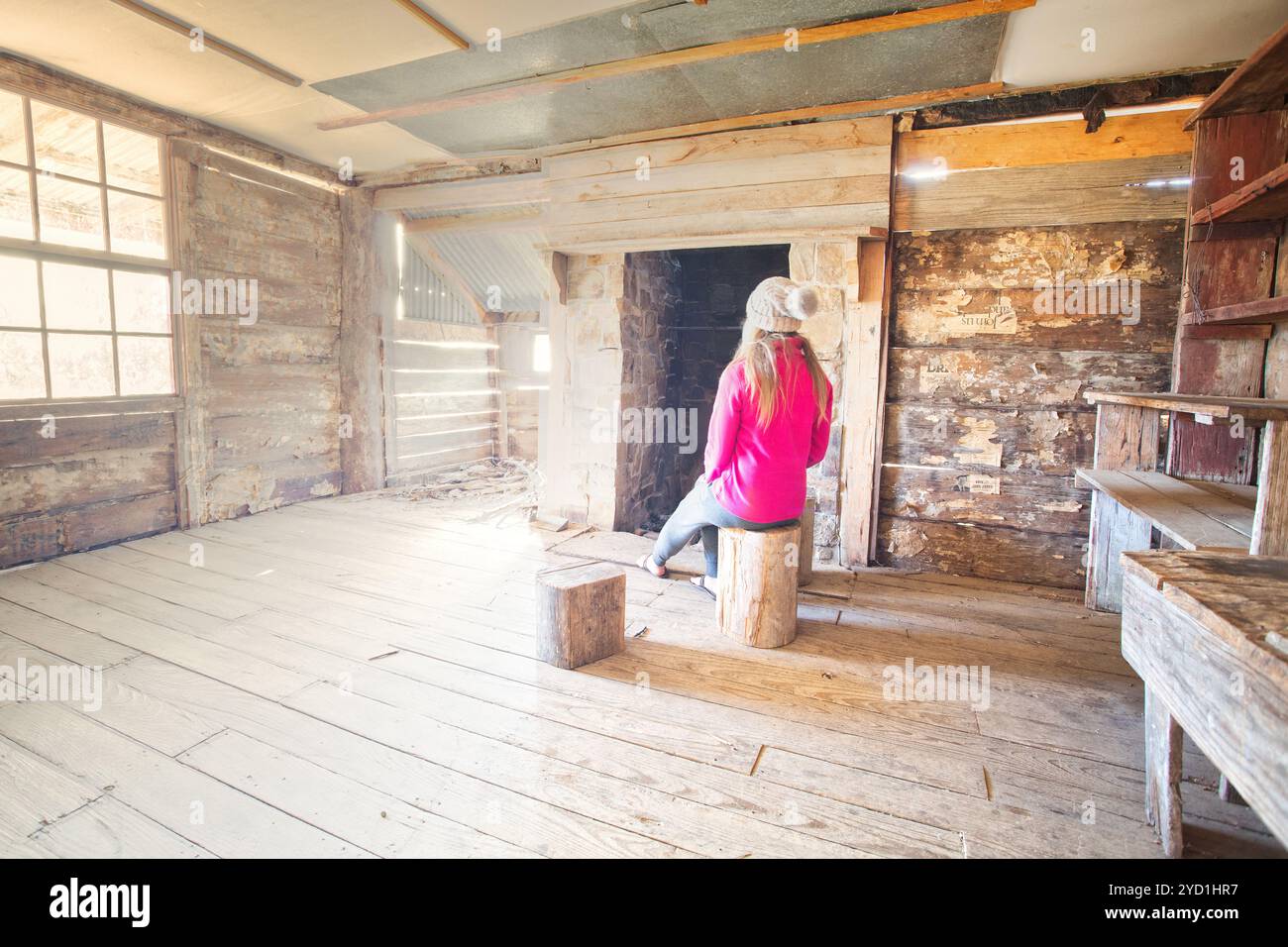 Sitting inside an old timber hut on log stools. These huts were made ...