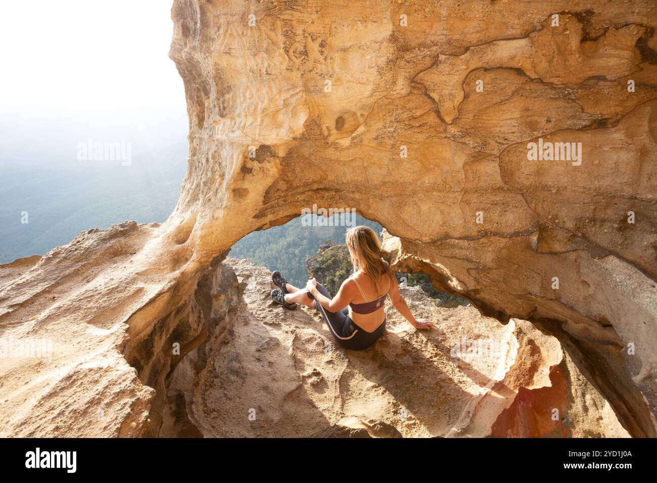 Female adventurer takes in cliff top cave views Blue Mountains Stock ...