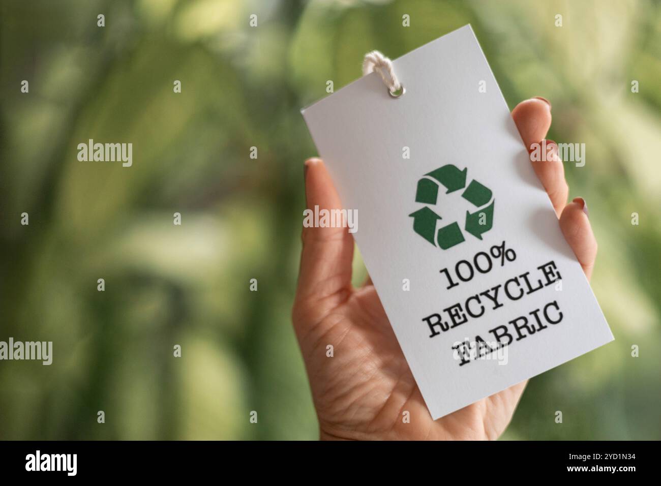 Hand takes a label with the inscription 100 percent recycle material ...