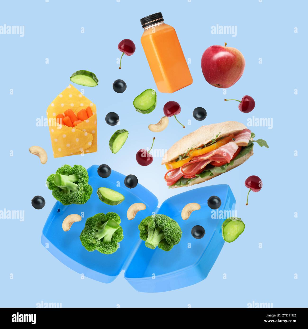 Lunch box, different food and bottle of juice in air on light blue ...