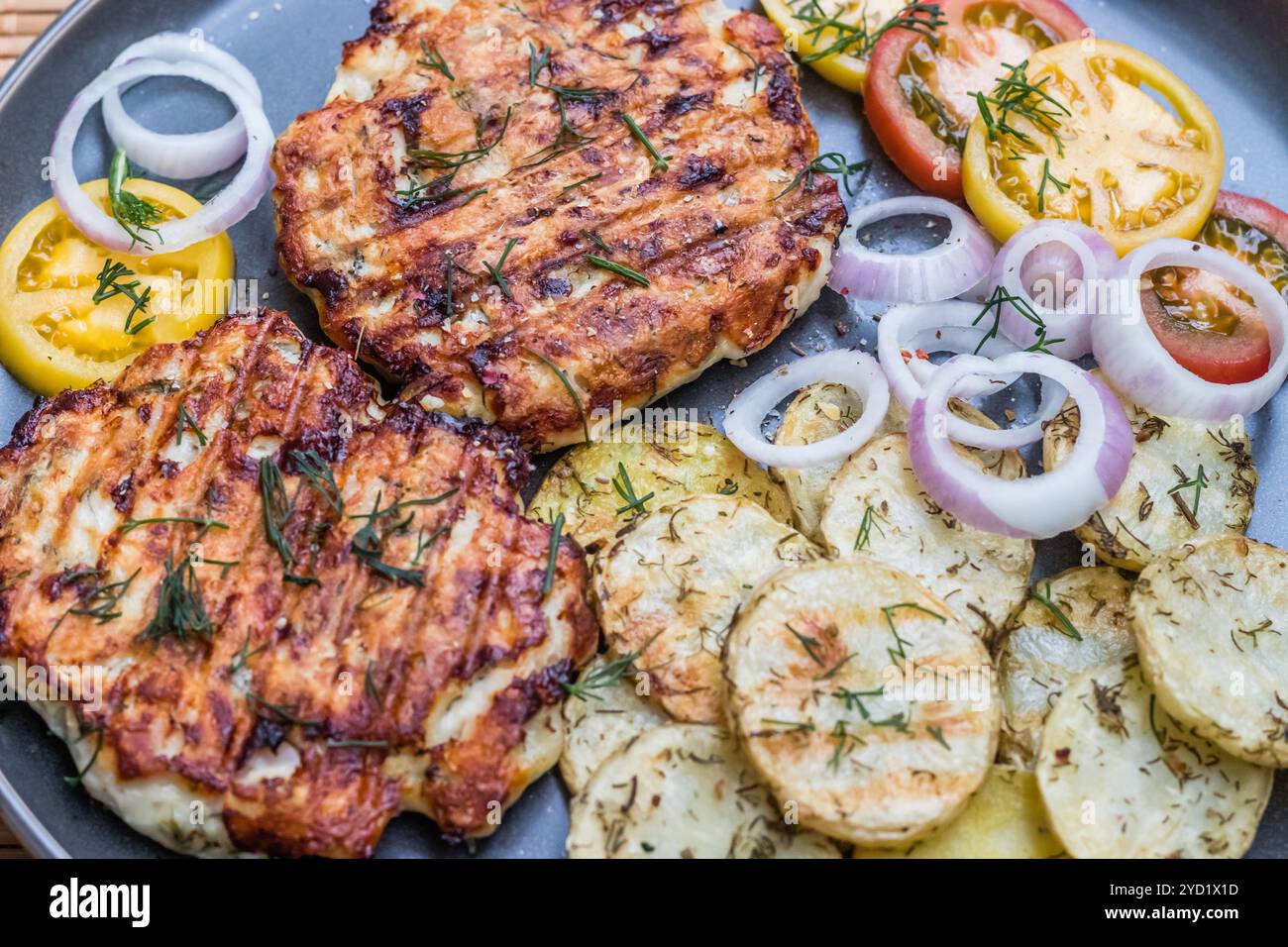 Chopped chicken cutlet with grilled vegetables lie on a plate. Grilled ...