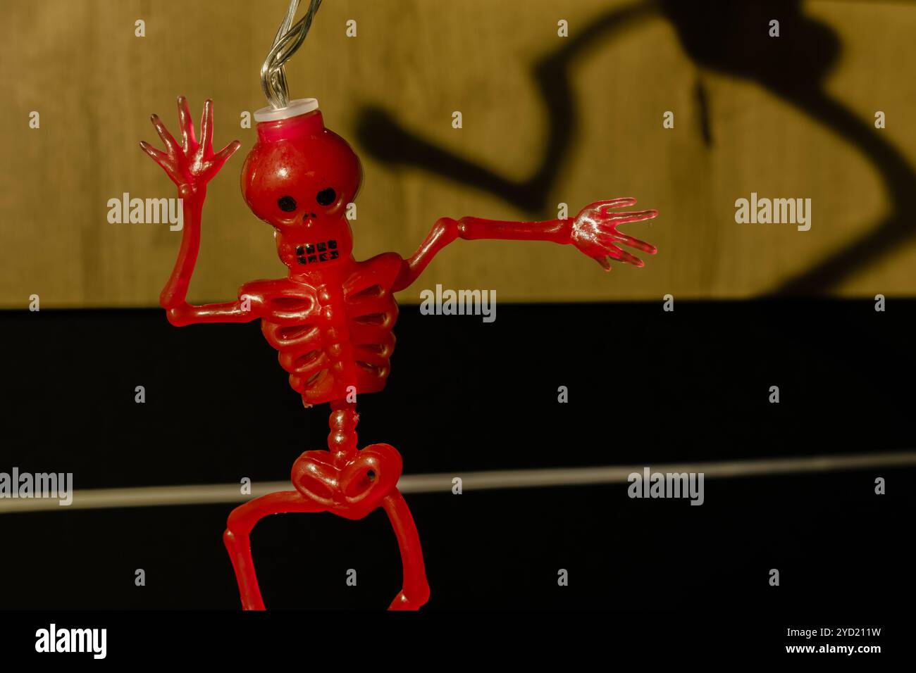 Red skeleton with a shadow behind him on black and yellow background ...
