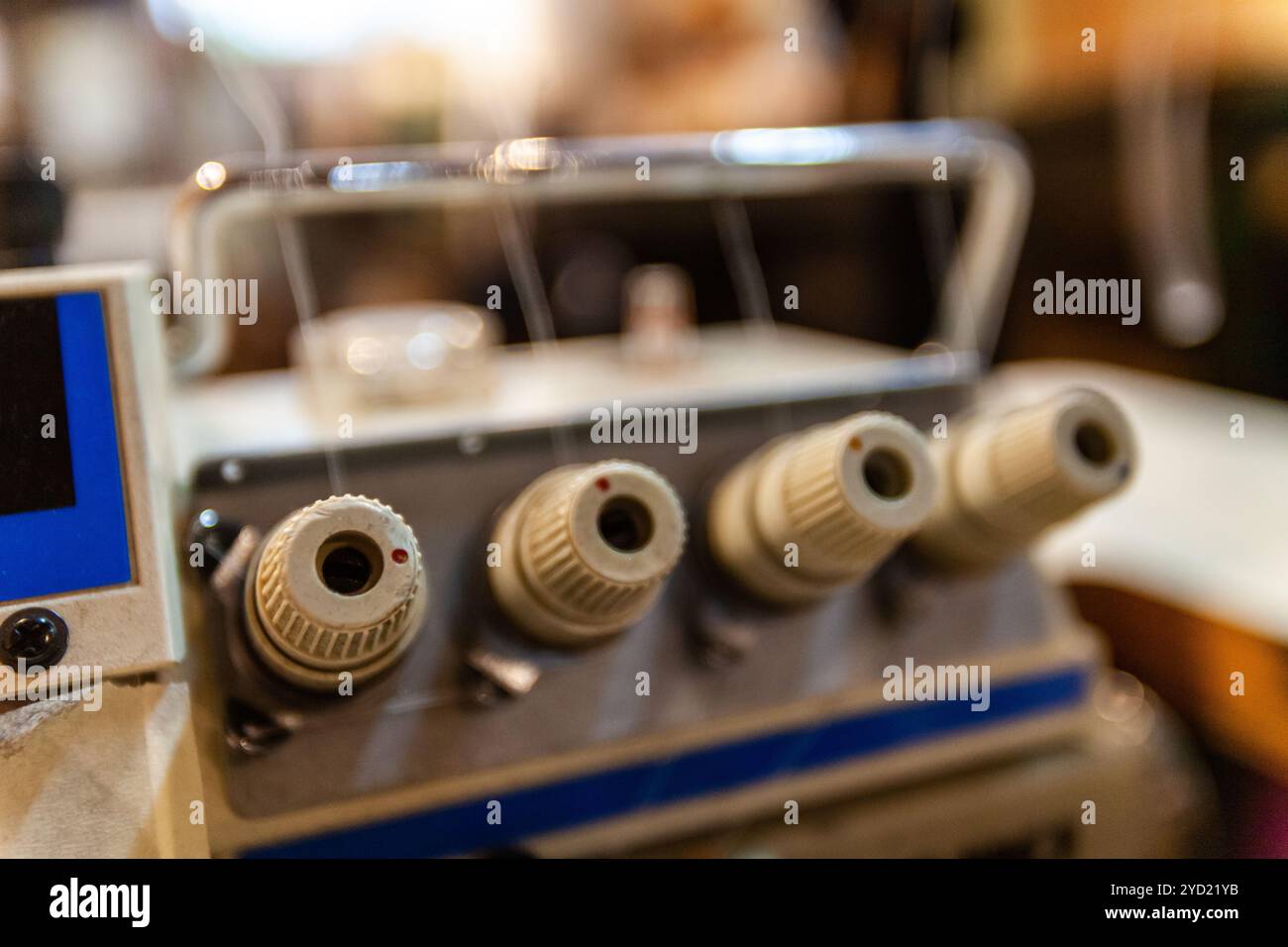 A closeup view of the spool control dials on a vintage overlock machine ...