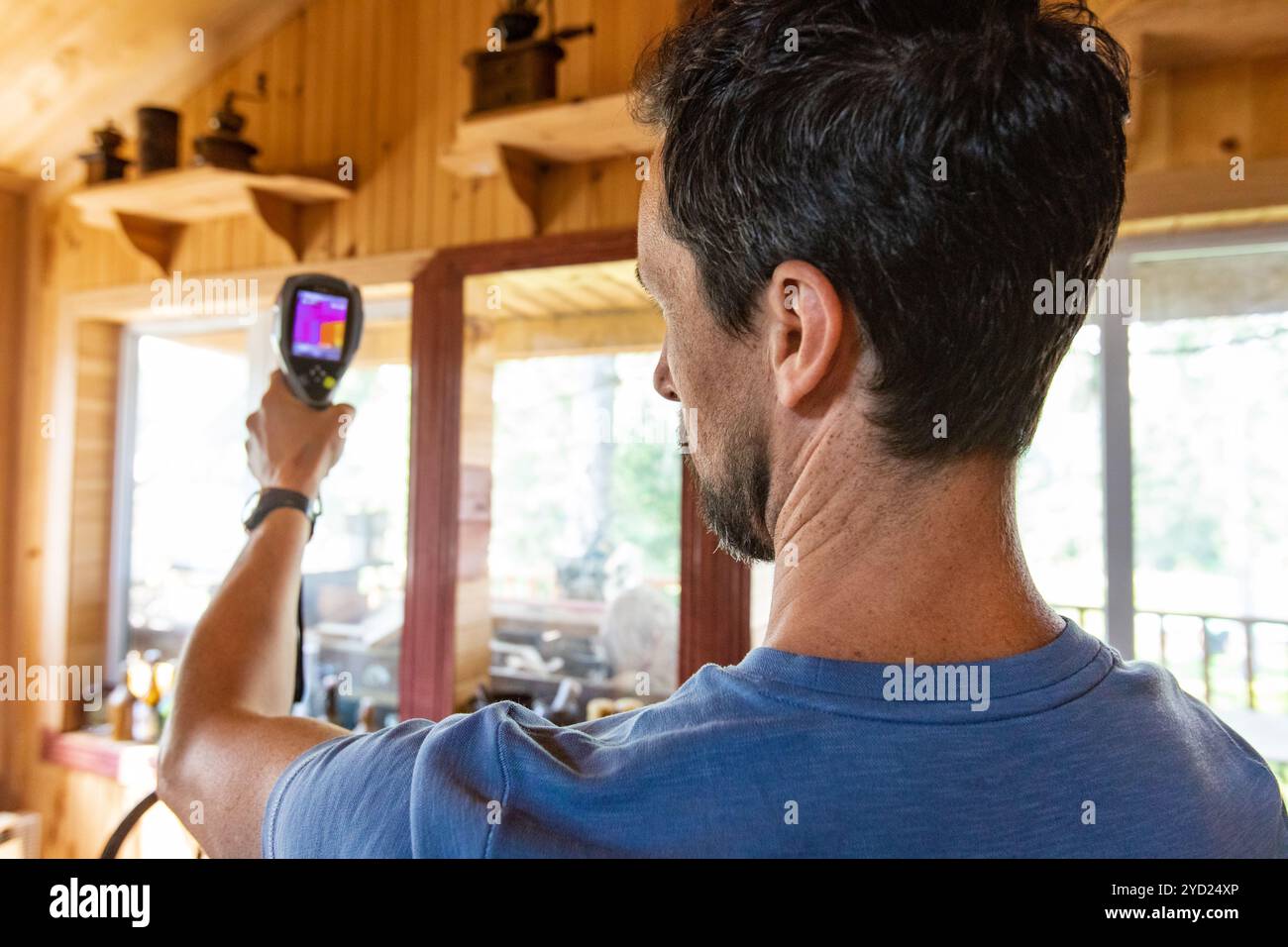 A close up and off to the side view of a man carrying out a home survey ...