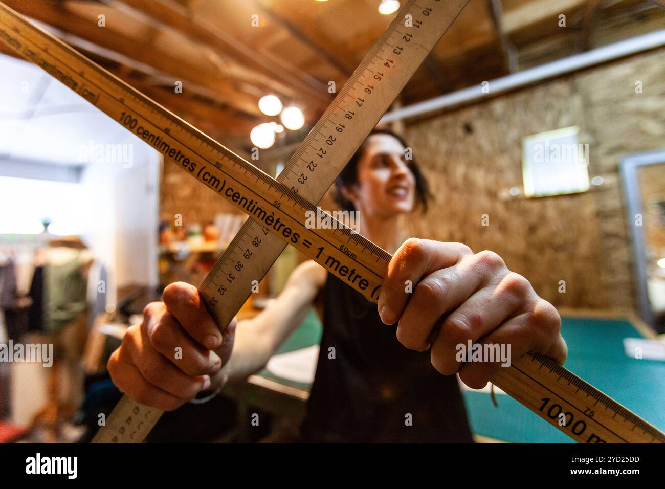 Fashion designer holding wooden rulers Stock Photo - Alamy