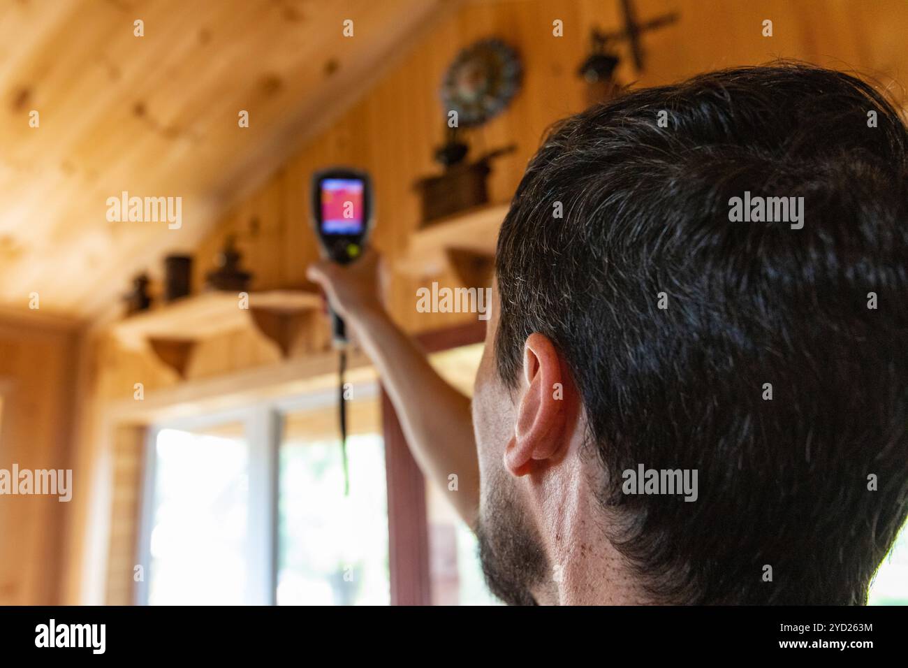 A close up and back of head view on a building surveyor carrying out a ...