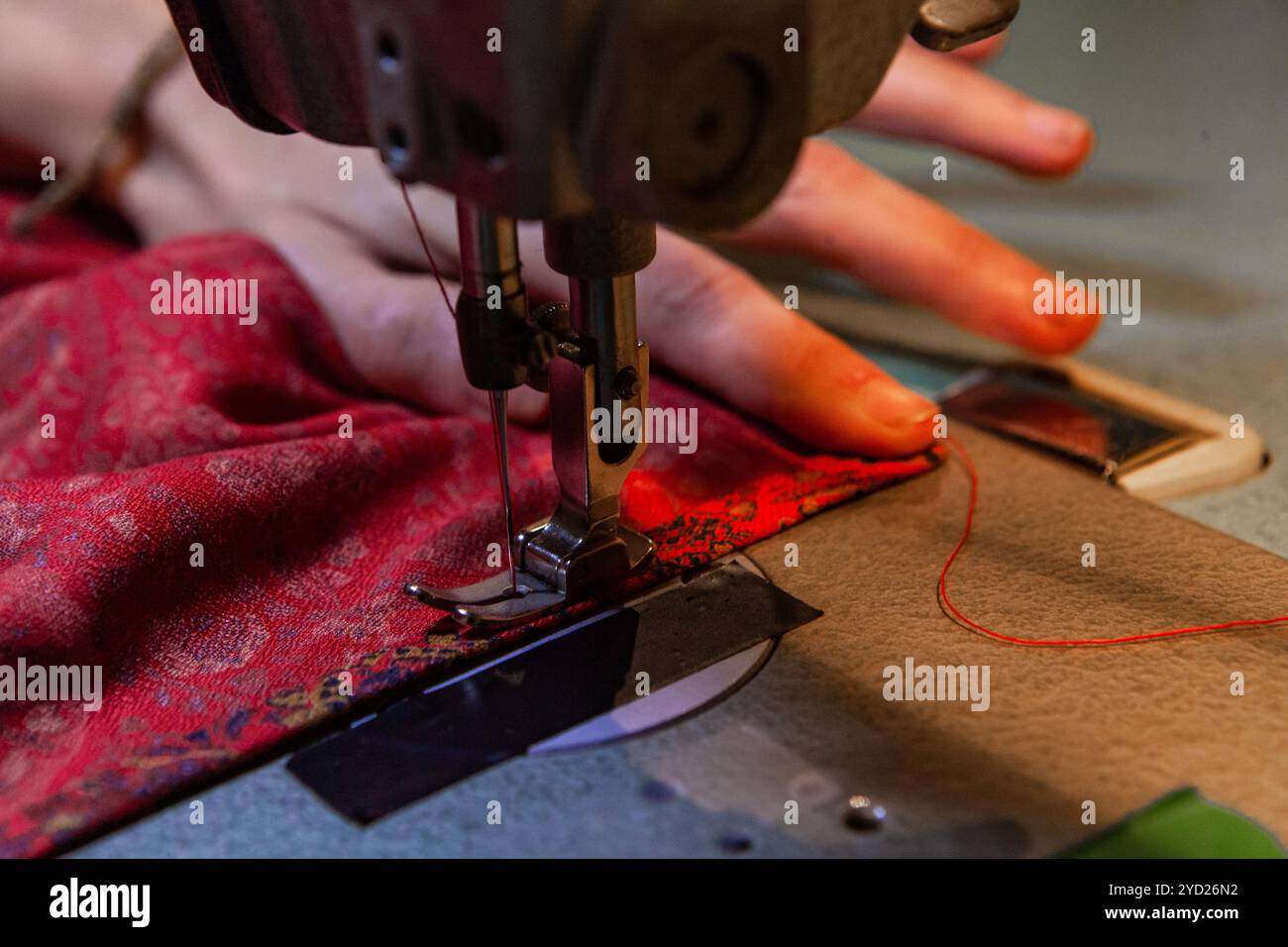 Red cloth on industrial sewing machine Stock Photo - Alamy