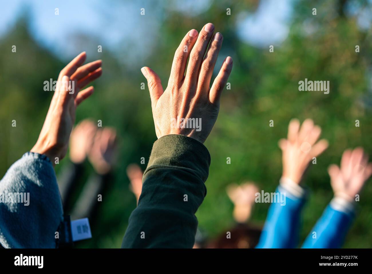 Group of people putting their hands up in the air Stock Photo - Alamy
