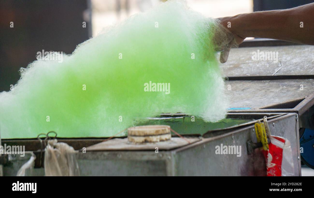 The seller is making gula kapas. Gula kapas is made from granulated ...