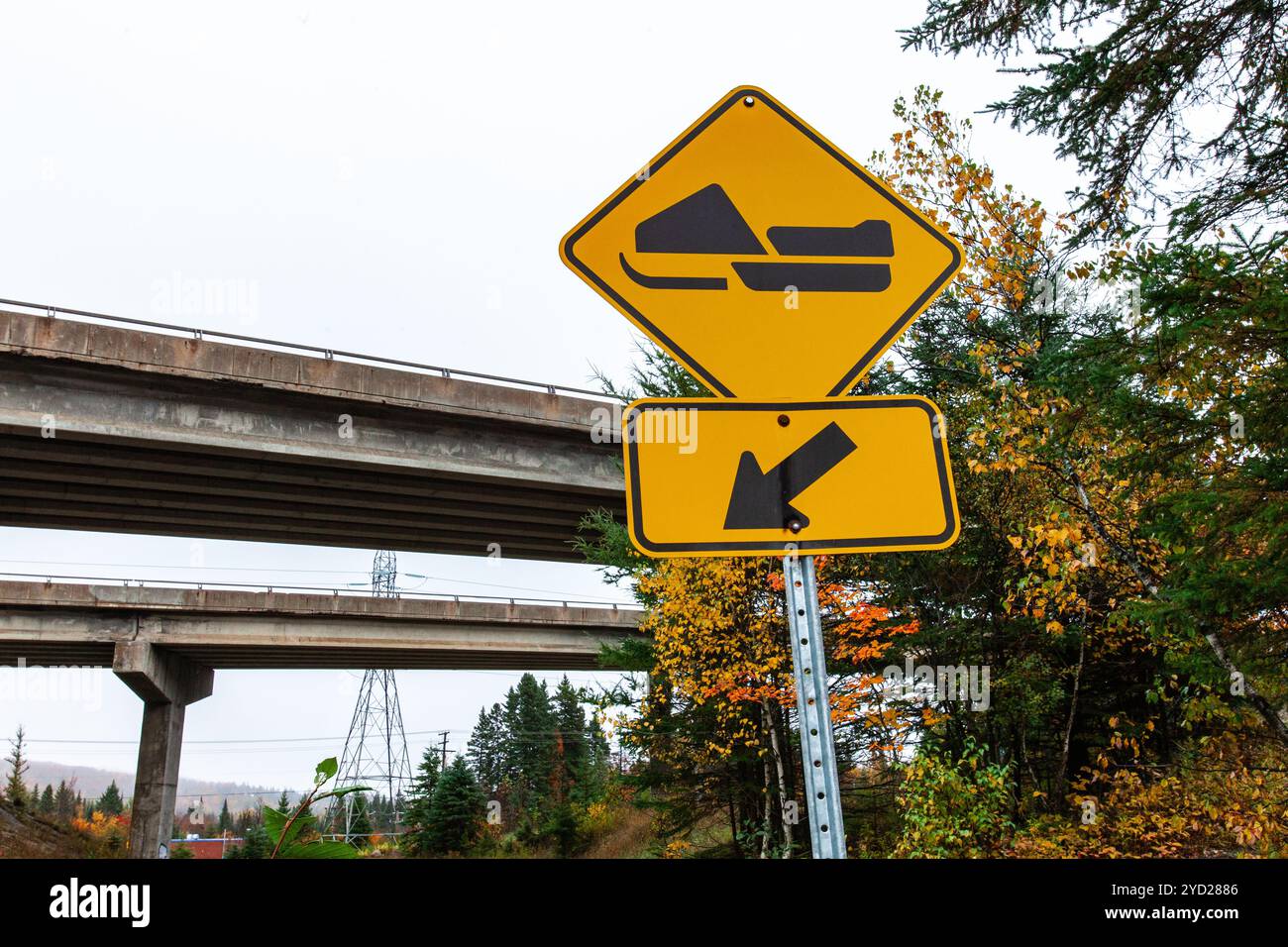 Snowmobile track to the left yellow road sign Stock Photo - Alamy
