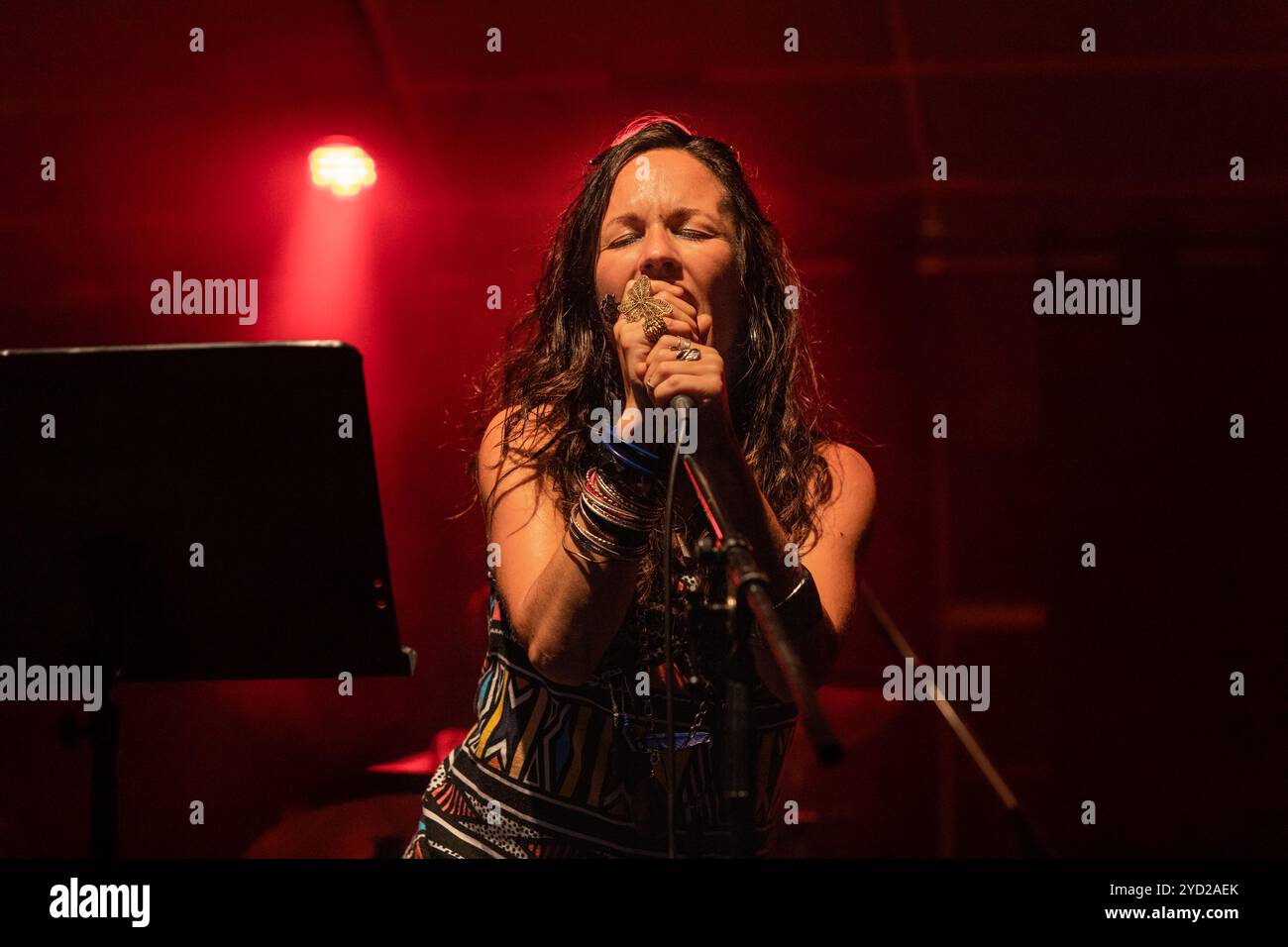 A female musician is viewed from a low angle as she sings with closed ...