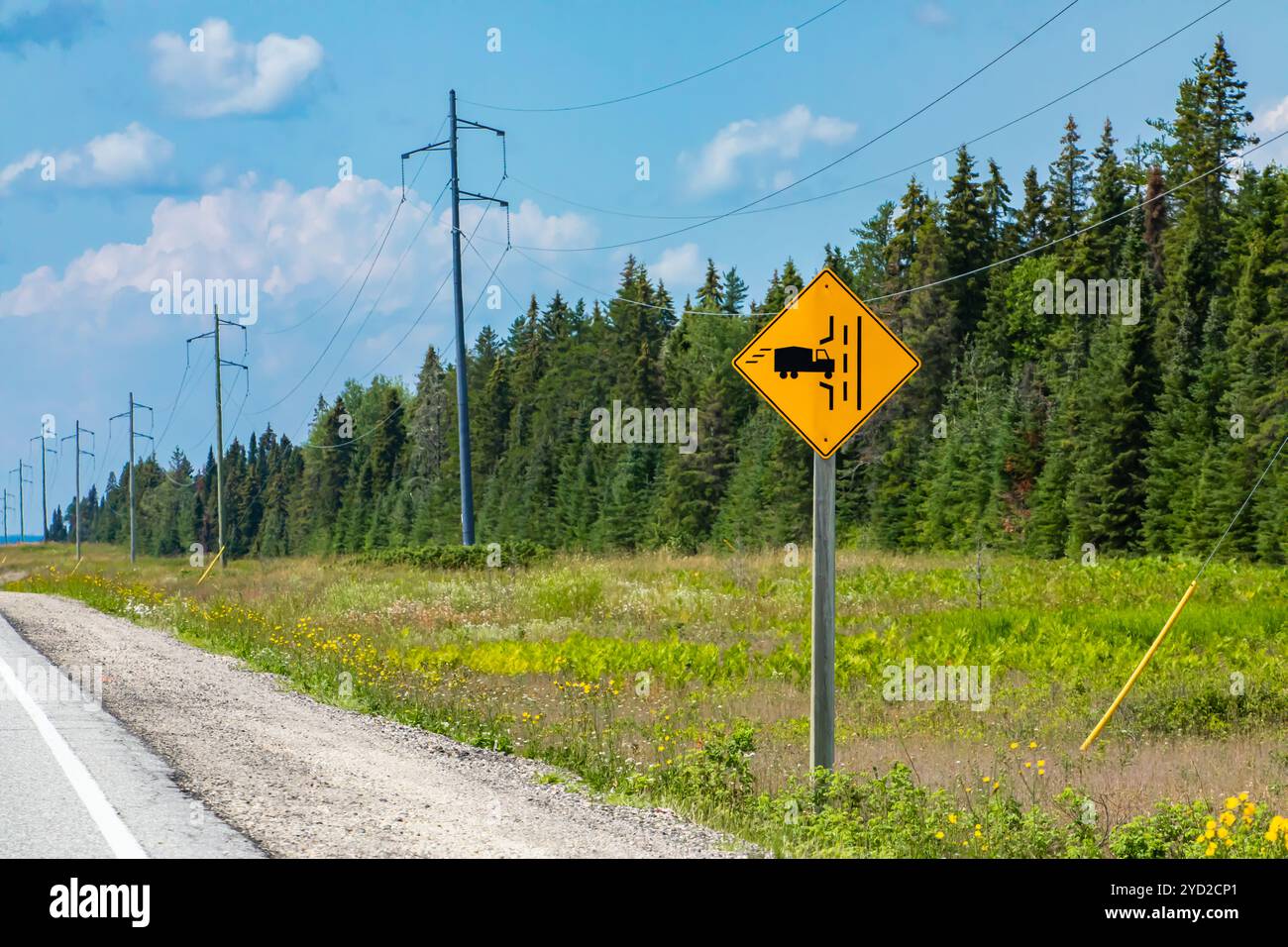 Truck entrance on the left side of the road ahead, a Warning sign on ...
