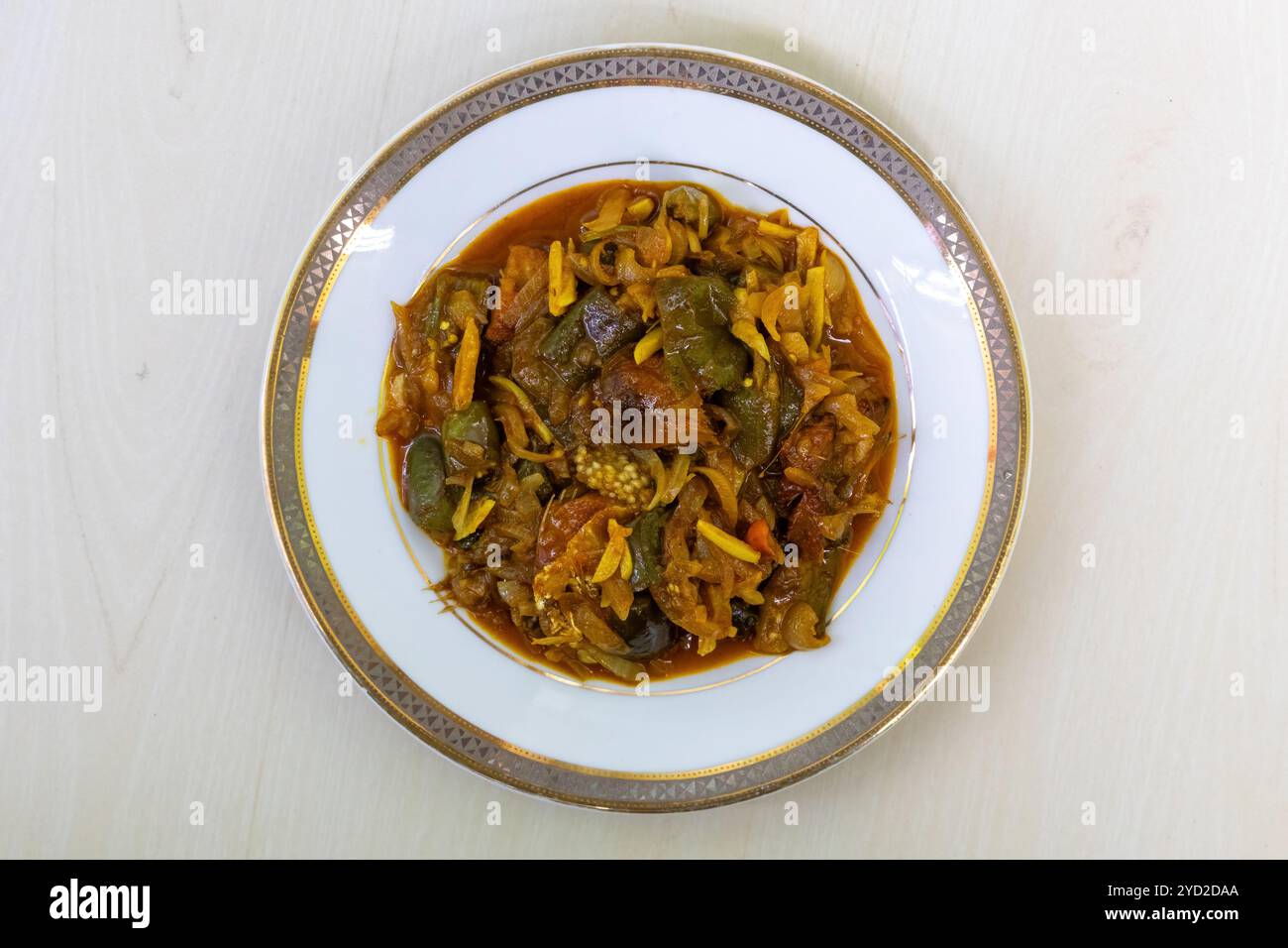 Nona ilish bhuna curry with brinjal on a white plate. Salted hilsa fish ...