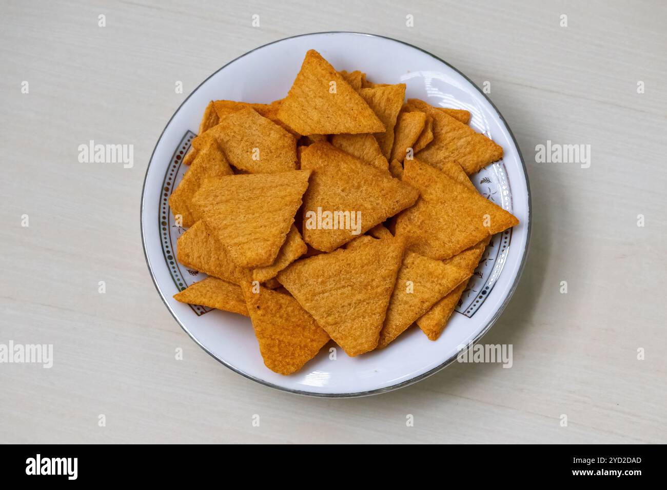 Crunchy and delicious triangular tortilla chips on a white plate in ...