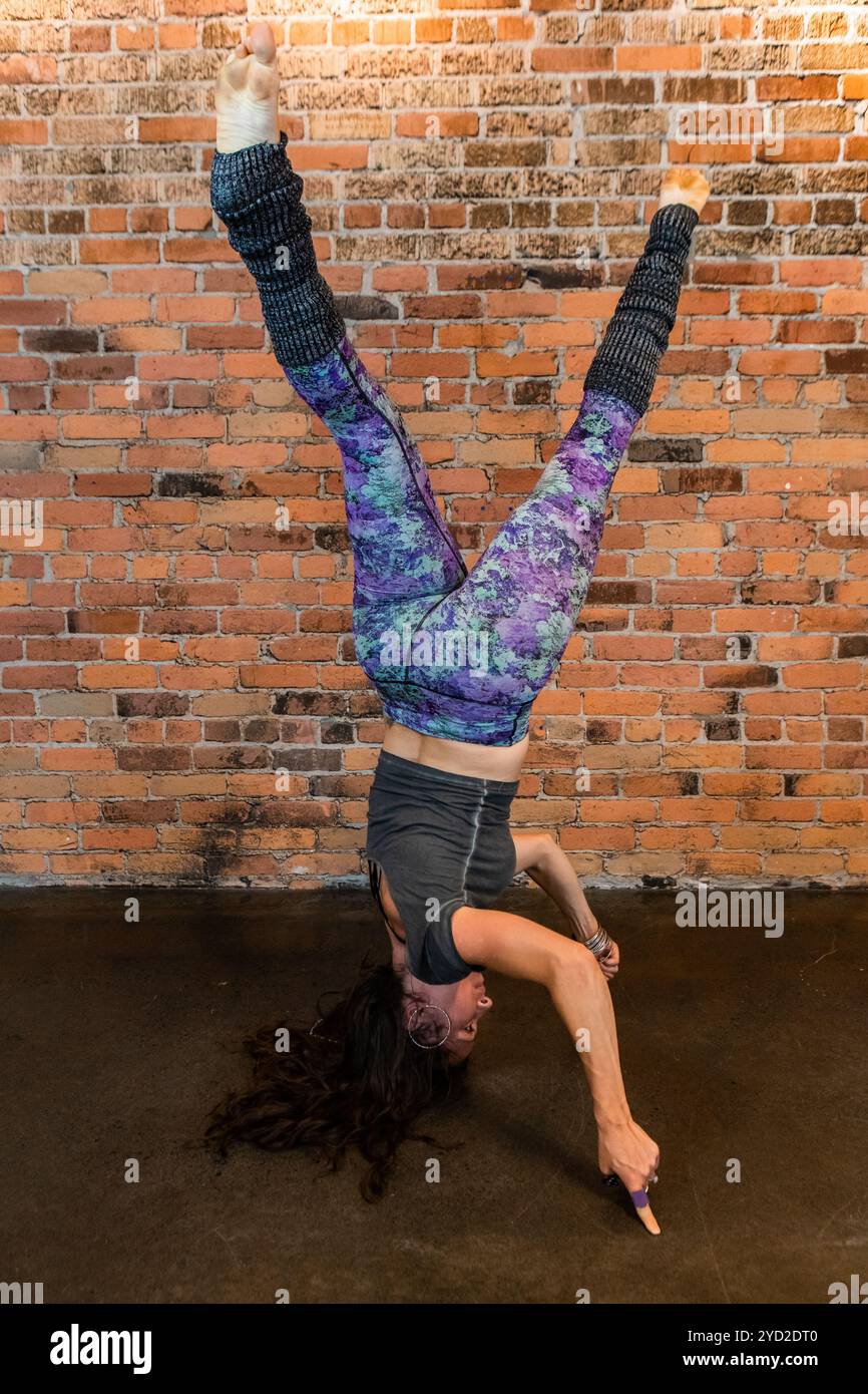 A side profile full body shot of an upside down woman as she performs a ...