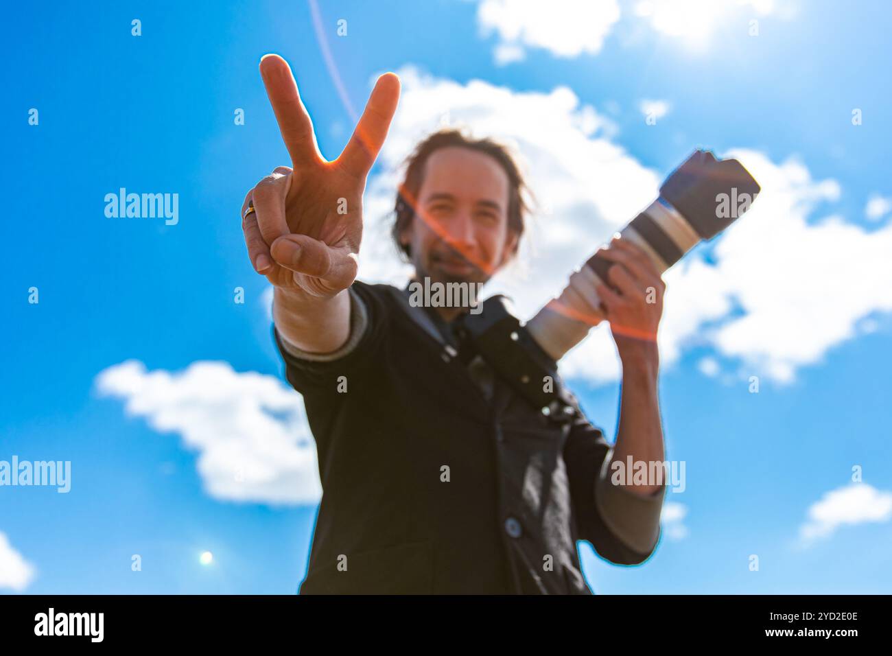 Successful photographer victory sign Stock Photo - Alamy