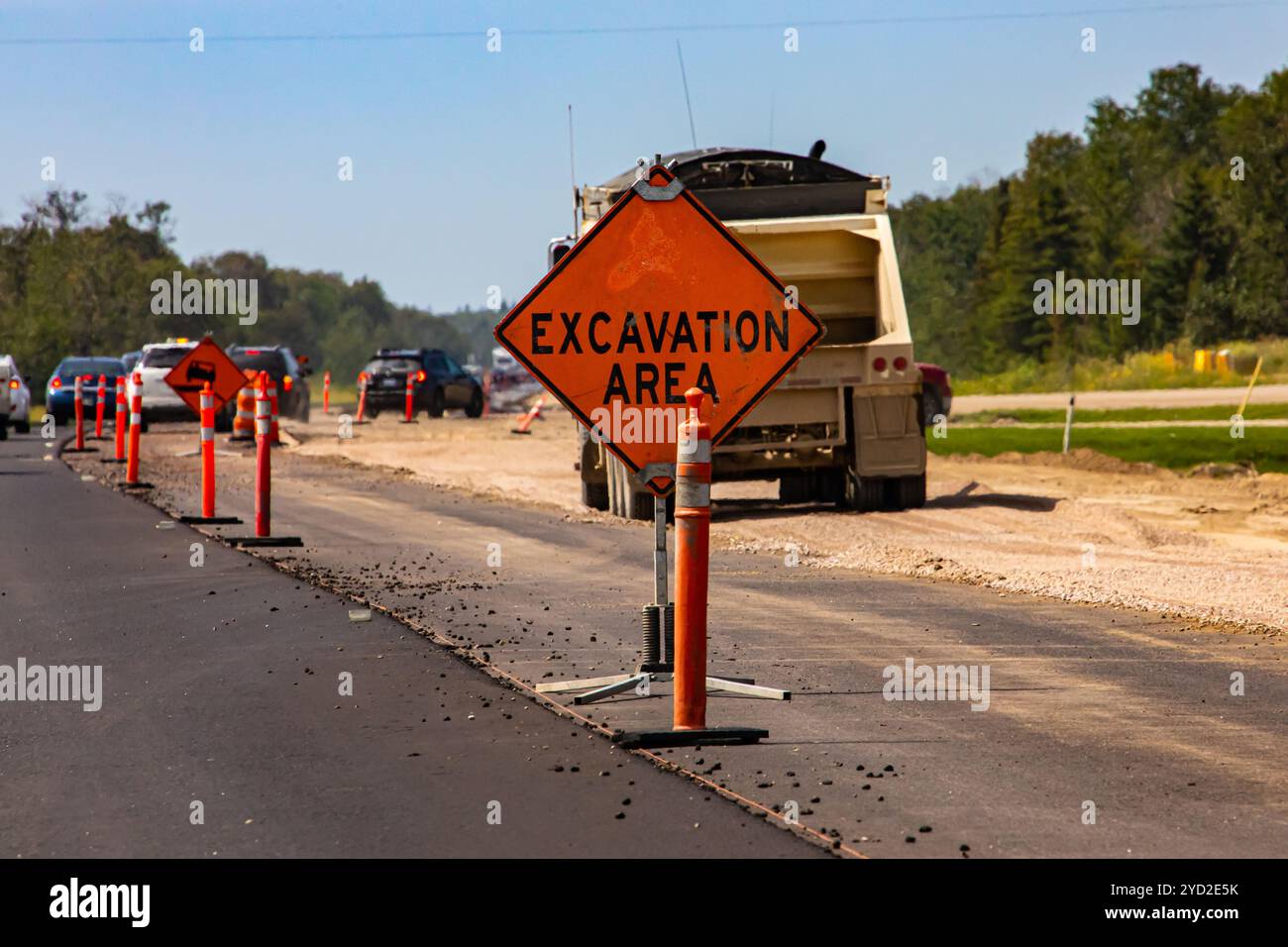 A close up shot of a bright orange warning sign saying excavation area ...