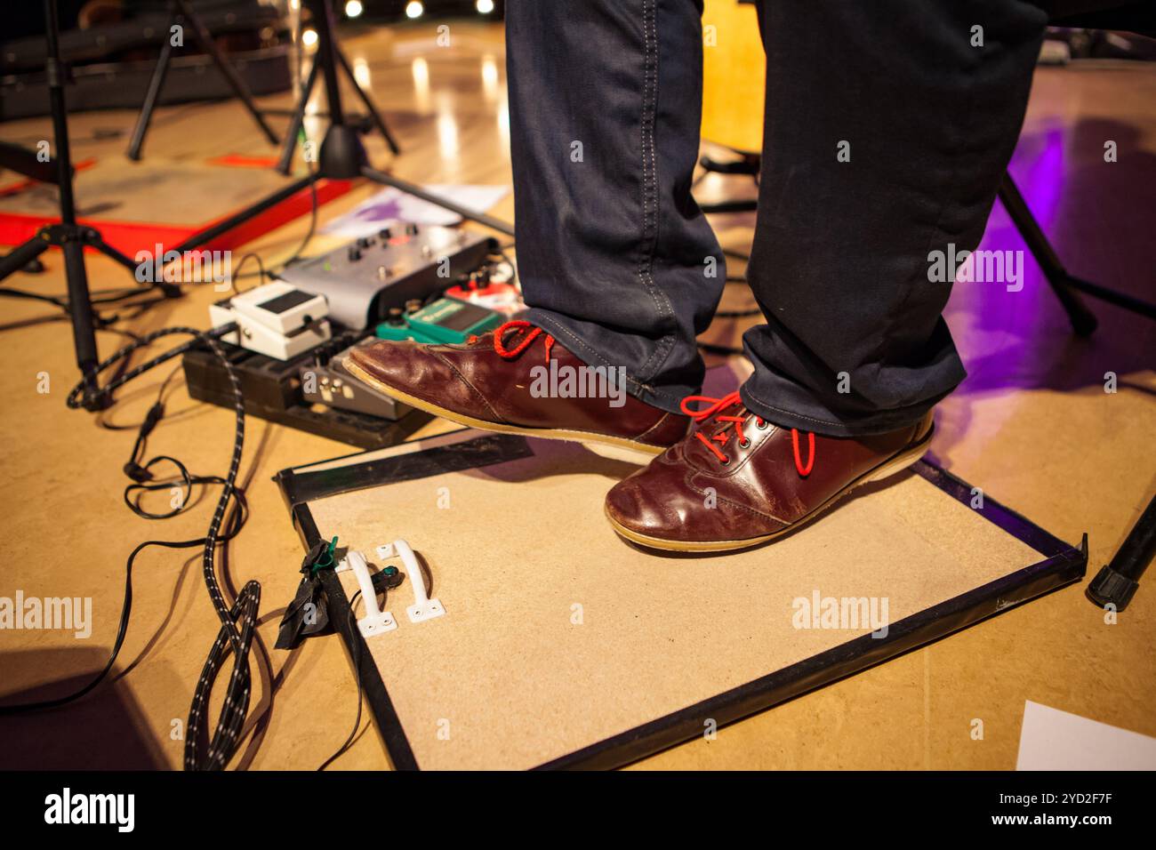 Feet tapping on a stage, with pedals and microphone stands in the ...