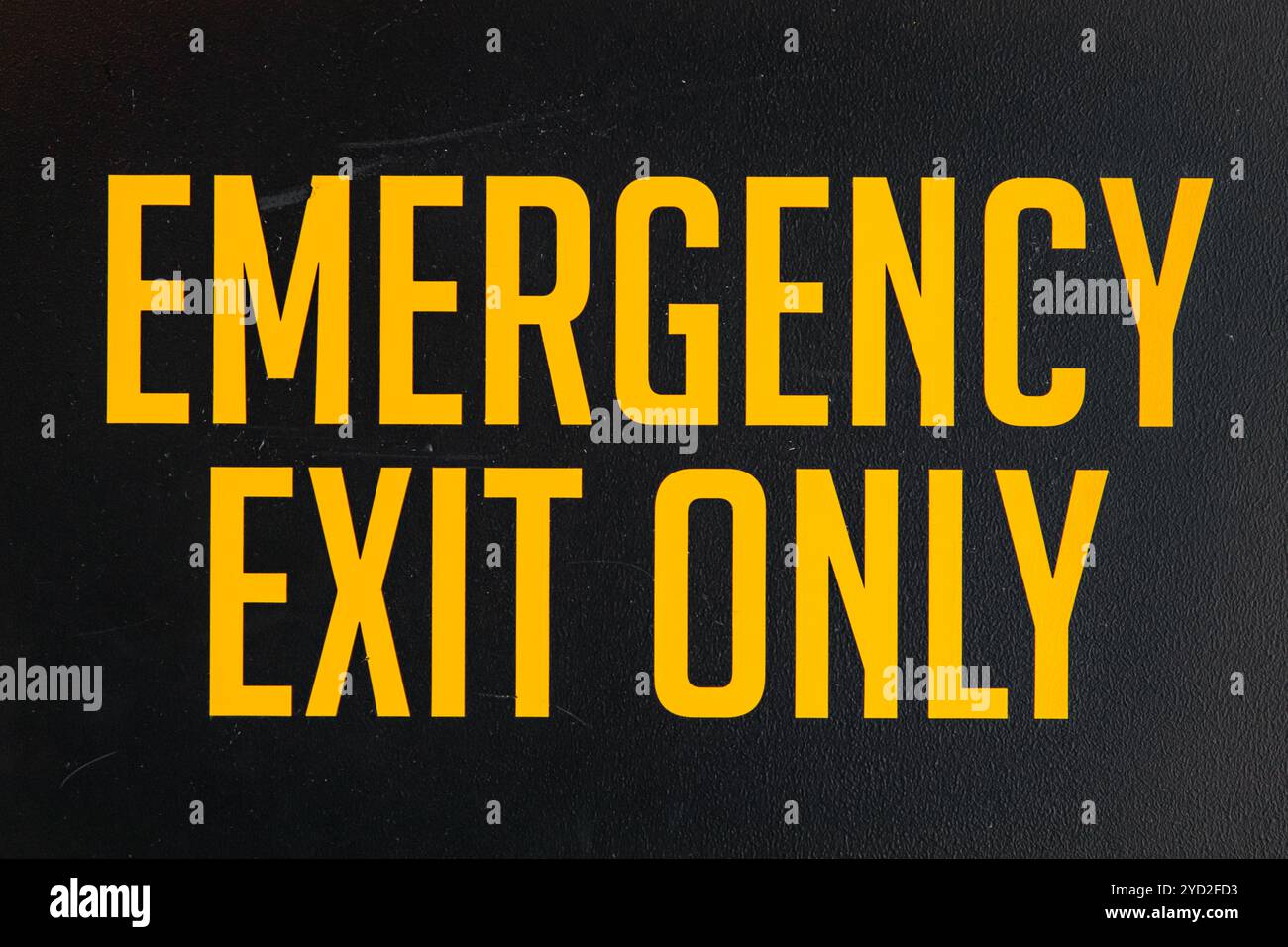 Emergency exit only yellow door sign Stock Photo - Alamy