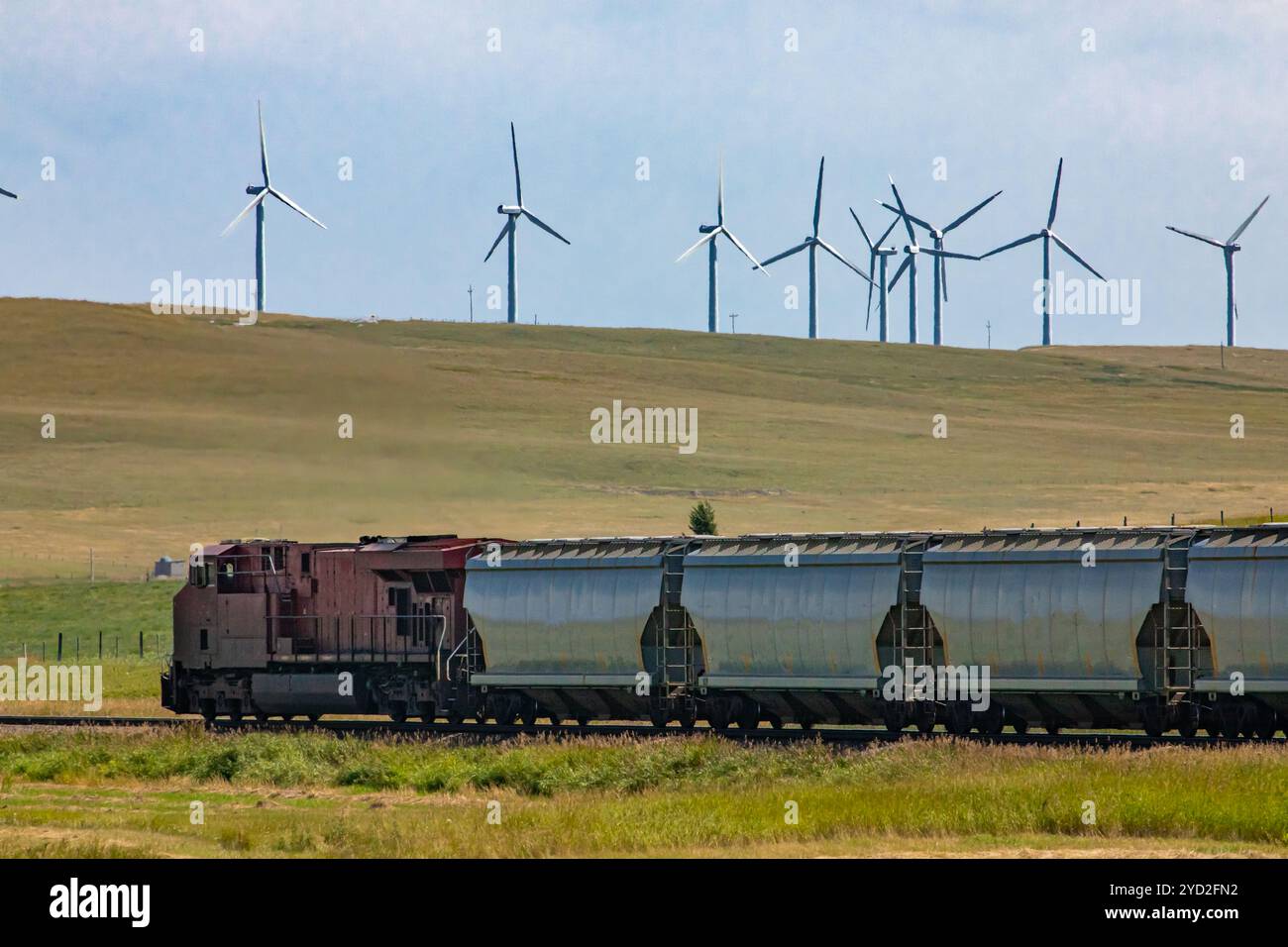 Row of metallic wagons of a Canadian freight train running between ...