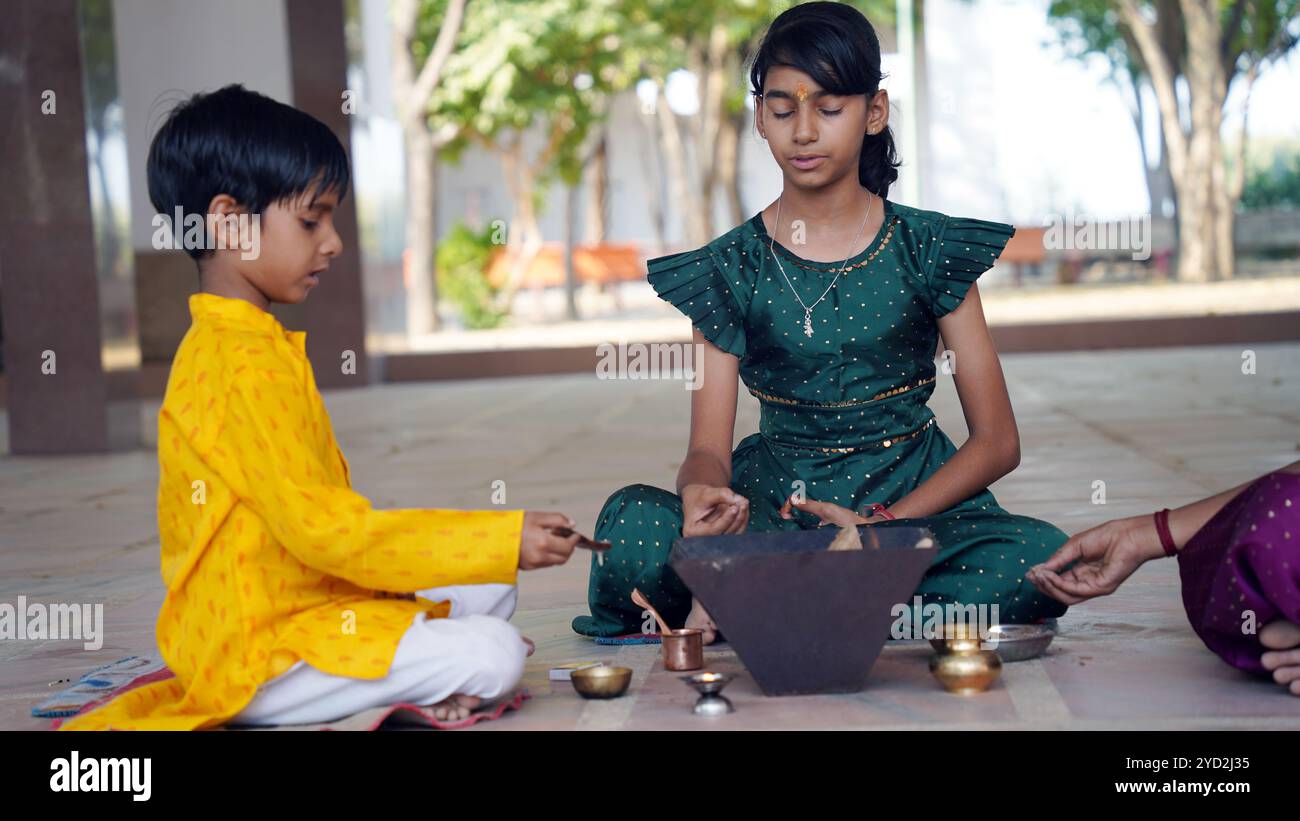 A Hindu family gathers around a sacred fire for Yagya during a festival ...