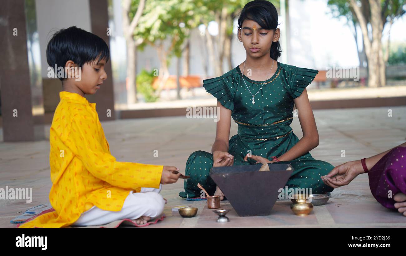 A Hindu family gathers around a sacred fire for Yagya during a festival ...