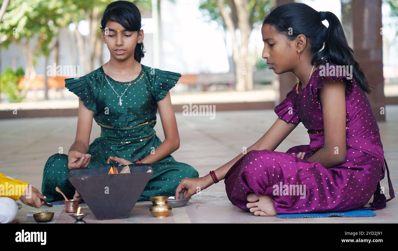 A Hindu family gathers around a sacred fire for Yagya during a festival ...