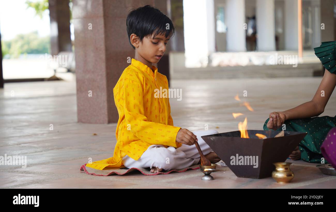 A Hindu family gathers around a sacred fire for Yagya during a festival ...