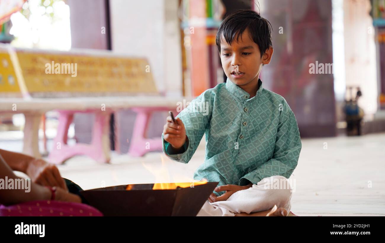 A Hindu family gathers around a sacred fire for Yagya during a festival ...