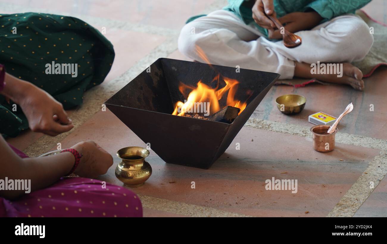 A traditional Indian family engaged in a sacred Yagya ritual to ...