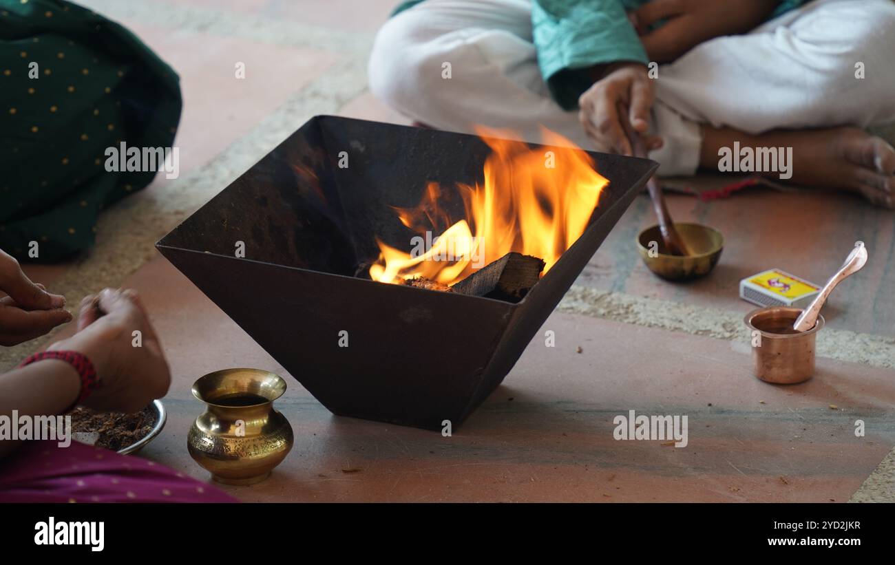 A Hindu family gathers around a sacred fire for Yagya during a festival ...