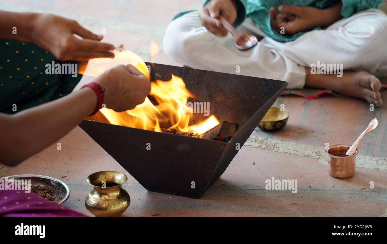 A Hindu family gathers around a sacred fire for Yagya during a festival ...