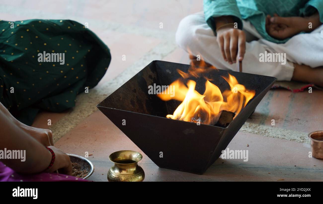 A Hindu family gathers around a sacred fire for Yagya during a festival ...