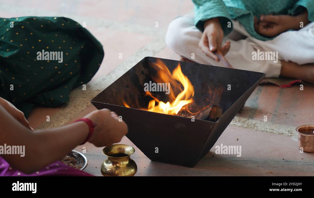 An Indian family in traditional attire performs a Yagya or Havan, led ...