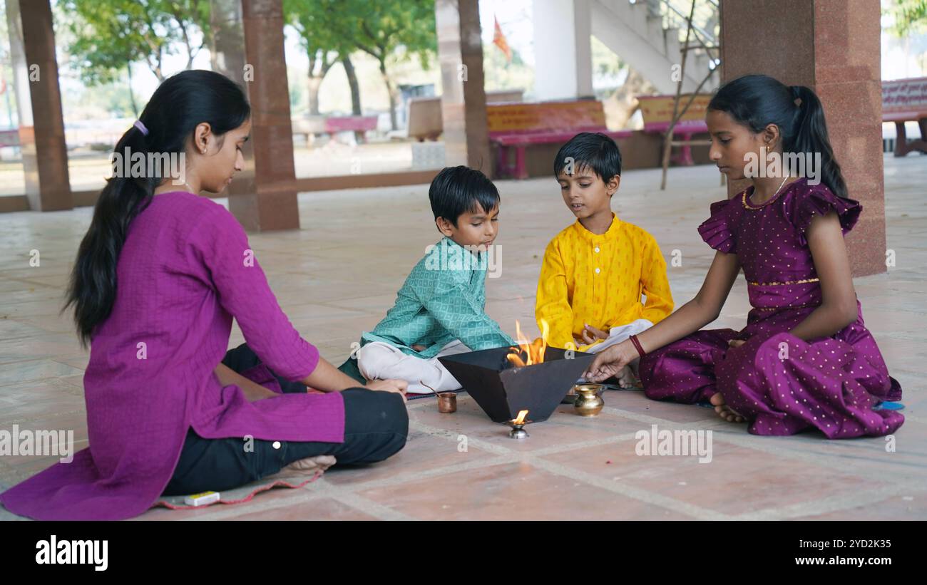 A Hindu family gathers around a sacred fire for Yagya during a festival ...